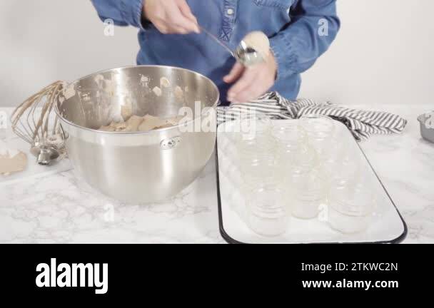 Step by step. Scooping homemade chocolate ice cream into glass jars ...