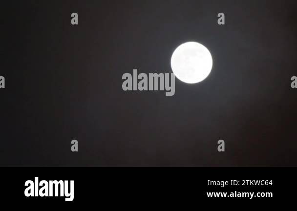 The full moon in the night sky glows through dark clouds. Mystical ...