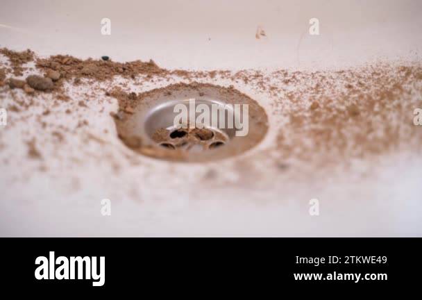 Washbasin drain in the sand close-up. Construction dust in the bathroom ...