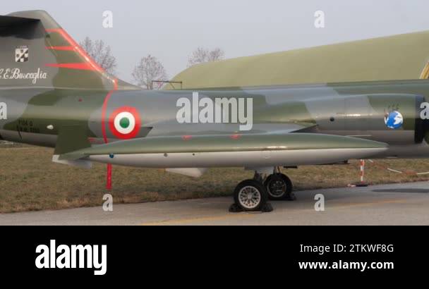 1950s supersonic fighter jet in green camouflage parked. Pan side view ...