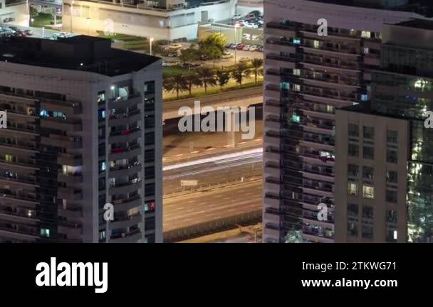 Dubai Marina towers night aerial timelapse. Glittering lights in windows and tallest skyscrapers ...