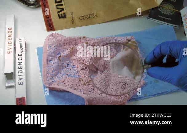 Police scientist inspects rape victim's underwear with a magnifying ...