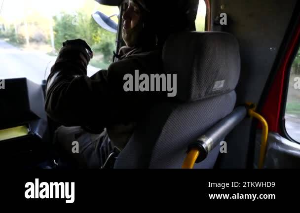 Young male firefighter in uniform riding on a big truck to place of ...
