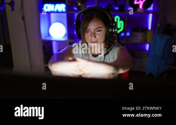 Young blonde woman streamer stretching arms playing video game at ...