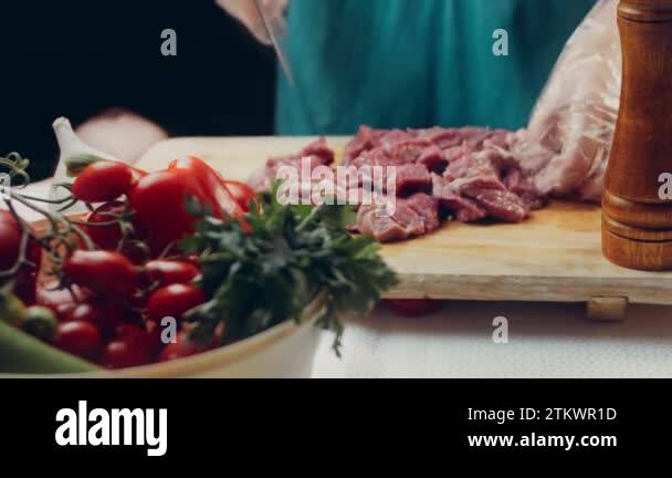 butcher cuts a large piece of selected meat on a steel table Stock ...