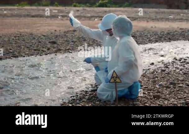 Ecologist sampling water from river with test tube glass and have white ...