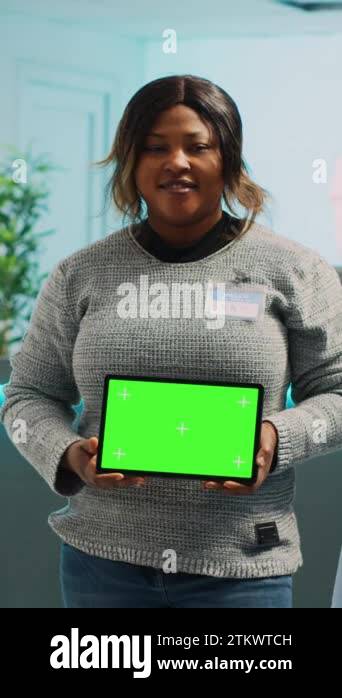 Vertical video: African american worker holding tablet with greenscreen ...