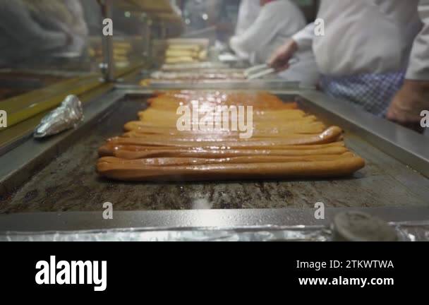 Hands unrecognizable male chefs grill traditional Bavarian sausages at ...