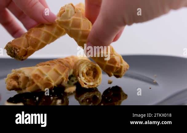 wafer rolls, home-baked dessert cookie female hands break homemade ...