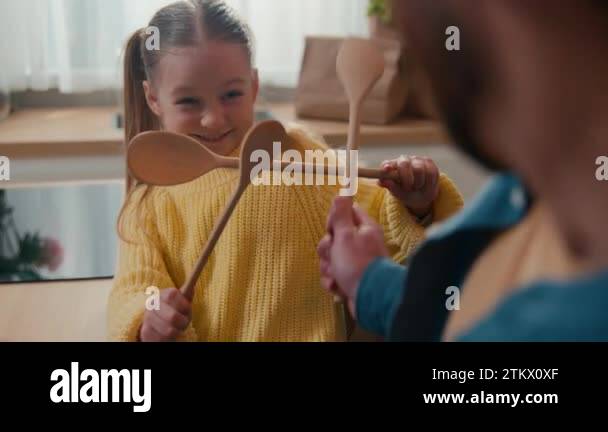 Unrecognizable dad father man and little daughter fighting with spoons ...