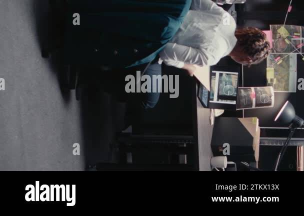 Vertical video: Team of inspectors analyzing case reports for details ...