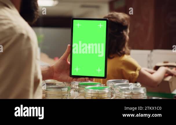 Customer uses mockup tablet in zero waste supermarket to check ...
