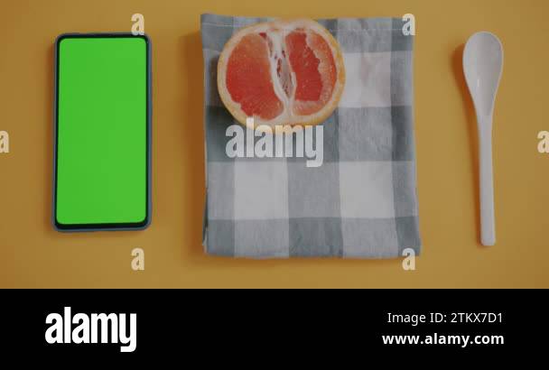 Flat lay of green screen chroma key smartphone and female hand putting ...