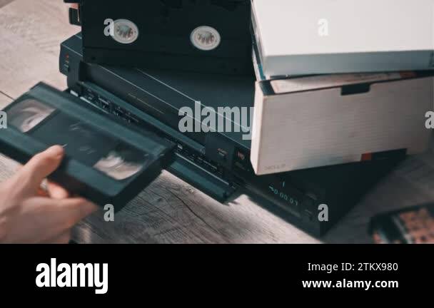 Insert VHS cassette into VCR player. Black vintage videotape cassette ...