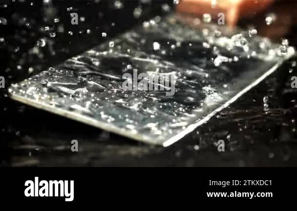 Drops of water fall on a butcher knife. Filmed on a high-speed camera ...