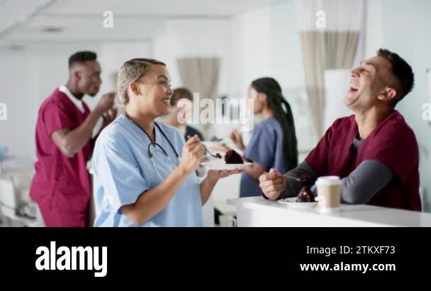 Happy diverse doctors eating birthday cake at reception desk in ...