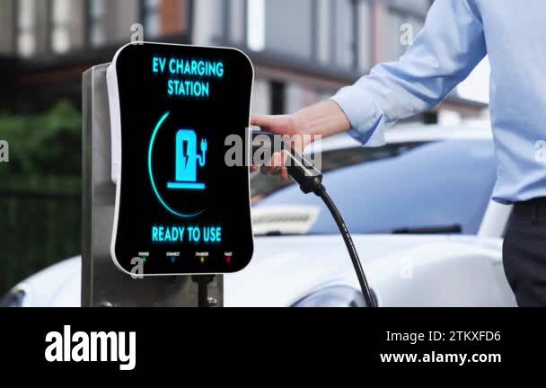 Businessman pull out EV charger from charging station to recharge ...