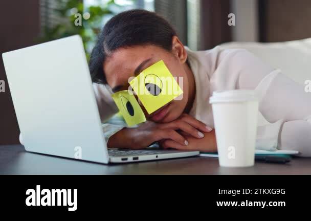 Distracted female office worker covering eyes with sticky notes while ...
