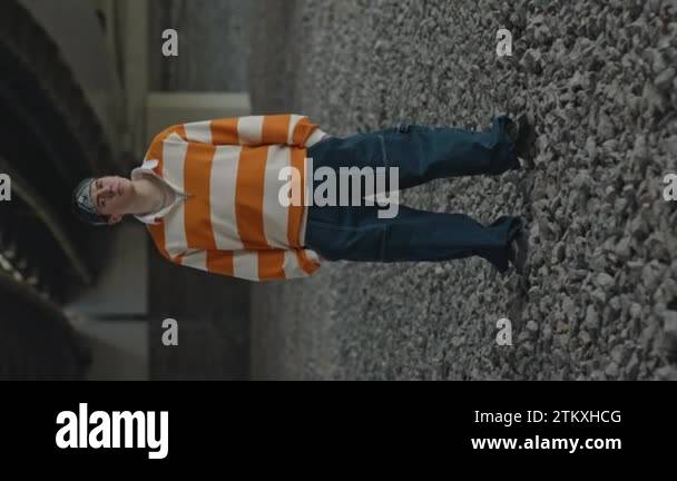 Vertical full length portrait of young Caucasian rapper in baggy ...