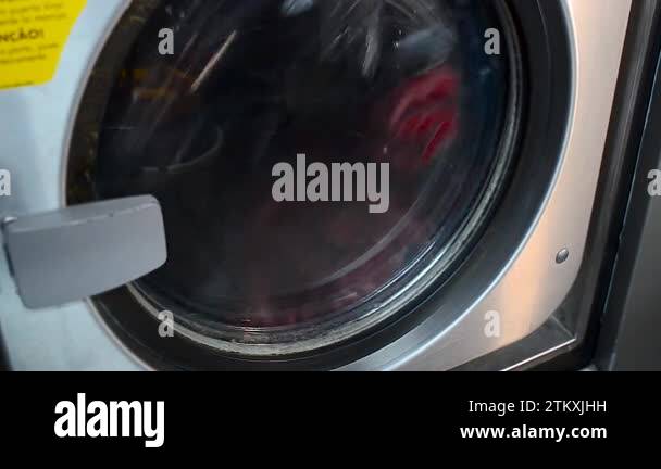 Washing clothes in a professional washing machine. Laundry room window ...