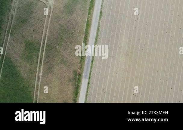 From a birds eye view, a rustic dirt road forms a dividing line between ...