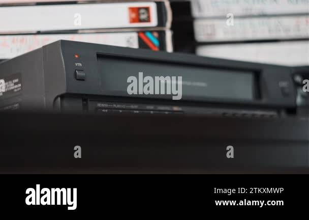 Insert VHS cassette into VCR. Black vintage videotape cassette recorder ...