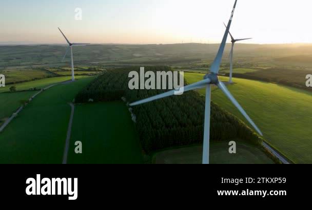 Aerial. Wind turbines standing at sunset. Aerial photo of a farm with ...