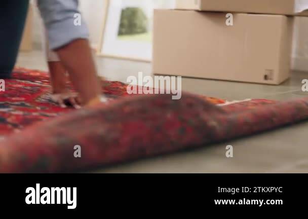 Real estate, teamwork and black couple rolling a carpet on floor in new ...