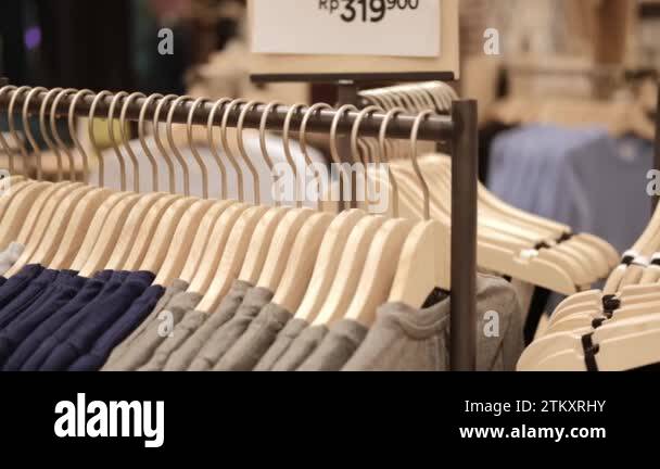 Close-up of hangers with clothes in a store, clothes for sale hang on ...