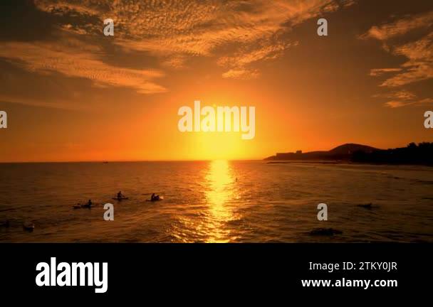 Surfers rides big wave against backdrop beautiful sunset on the sea ...