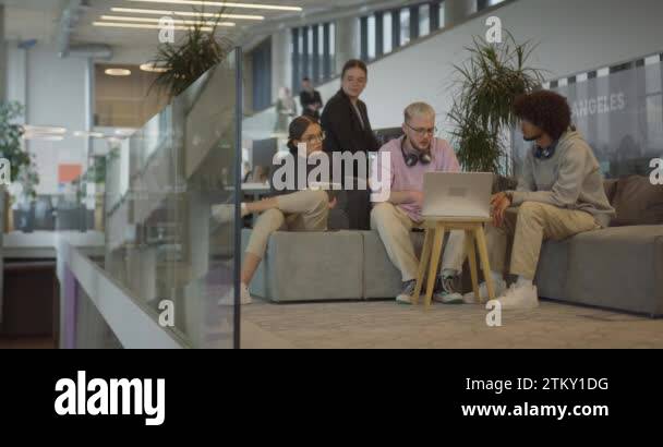 A diverse group of colleagues exchange business experiences, engage in ...