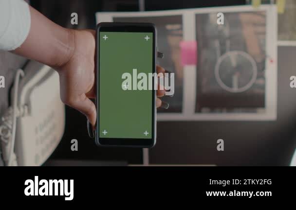 Vertical video: Police officer using greenscreen in evidence room ...