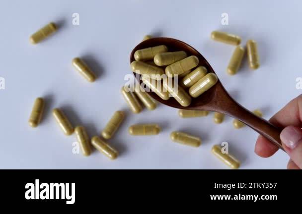 Transparent capsules with yellow-beige powder inside. A supplement or ...