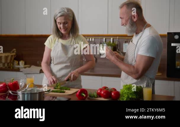 Retired old couple happy Caucasian family cooking in kitchen woman chef ...