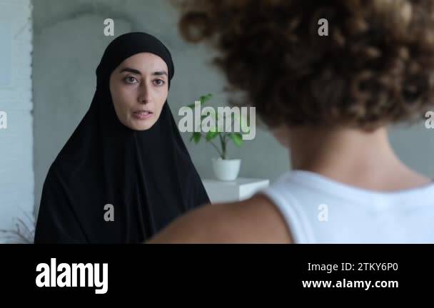 A Muslim woman in a hijab tells a European woman about Sharia rules ...