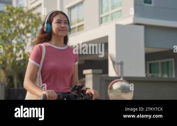Young woman happy smile girl go green asia people ride EV bike push ...