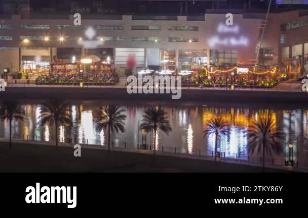 Walking promenade along water canal with many crowded restaurantes in ...