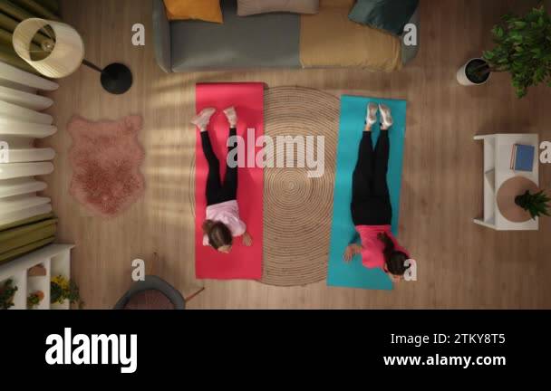 Woman and child stand on fitness mats and perform an exercise, warm up ...