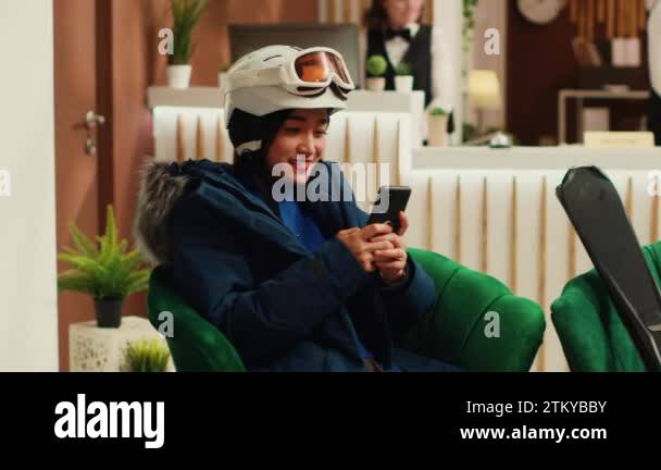 Woman messaging on smartphone, asking people to meet skiing on snowy ...