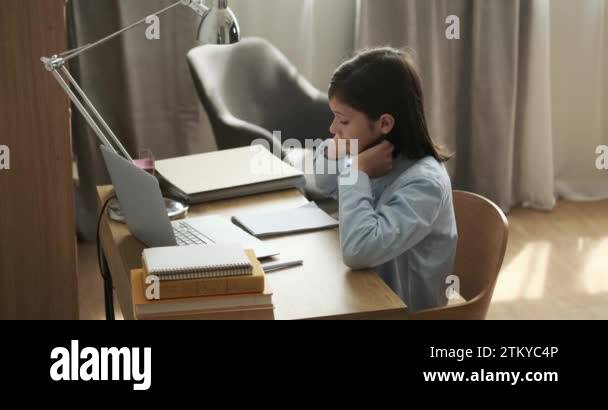 Diligent schoolboy sits at desk, completely absorbed in studies. His ...