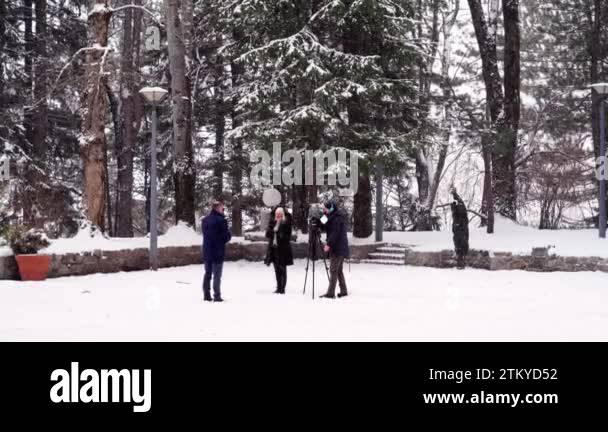 Cameraman is shooting a story with a woman and a man standing under ...