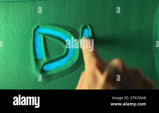 Hand drawing the Deutsche Mark currency symbol in the Green Sand. Male ...