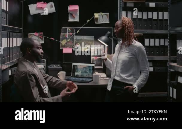 Police agents doing background checks for investigation in archive room ...