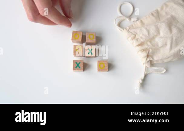 Wooden dice game TIC-TAC-TOE on a grey background with white bag with ...