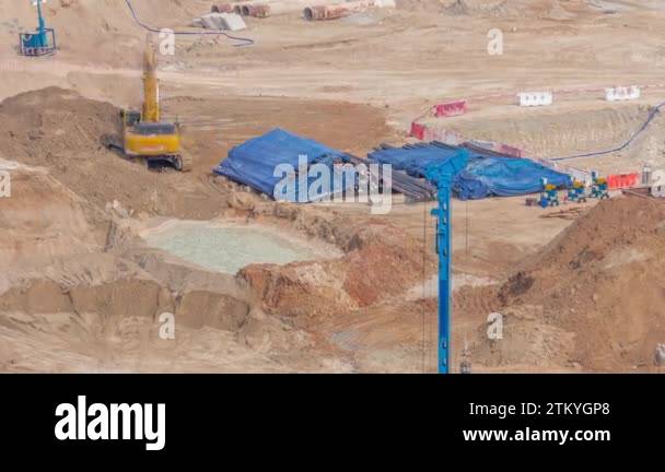 Pile driving in foundation pit for construction of apartment complex building aerial timelapse ...