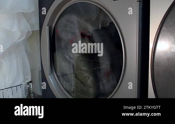 Washing clothes in a professional washing machine. Laundry room window ...
