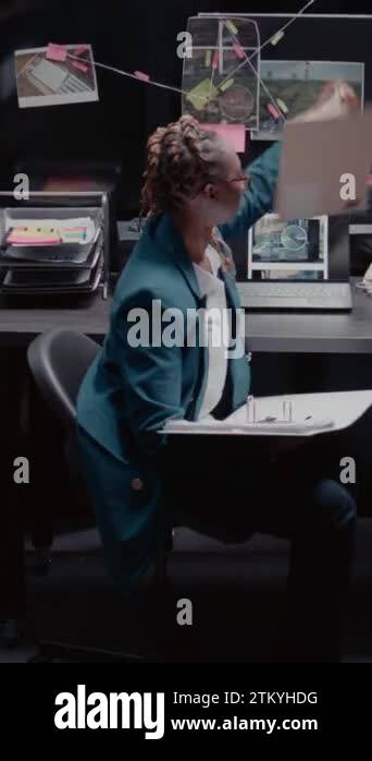 Vertical video: Private investigator reviewing new case evidence on ...