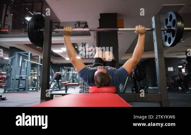 February 21, 2023 Ukraine, Dnipro.Barbell bench press. A young athlete ...
