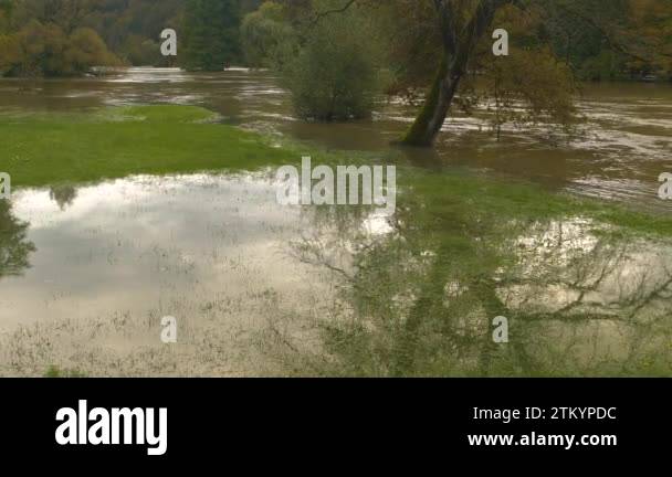 Raised water level of a fast-flowing muddy river after heavy spring rainfall. Raging river, full ...