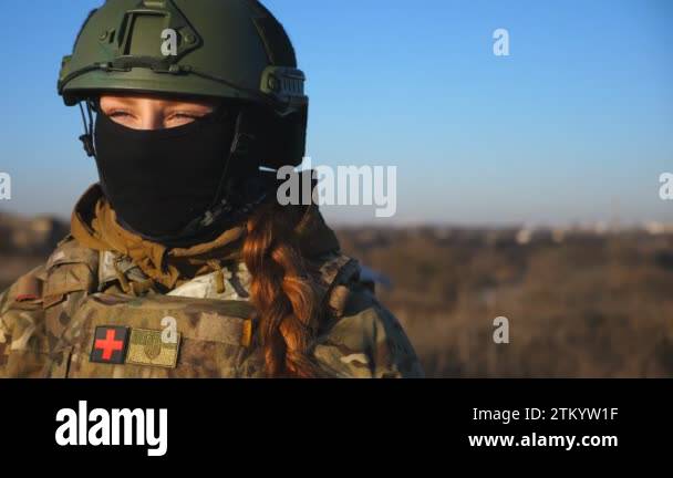 Happy military woman in helmet and balaclava fooling around around on ...